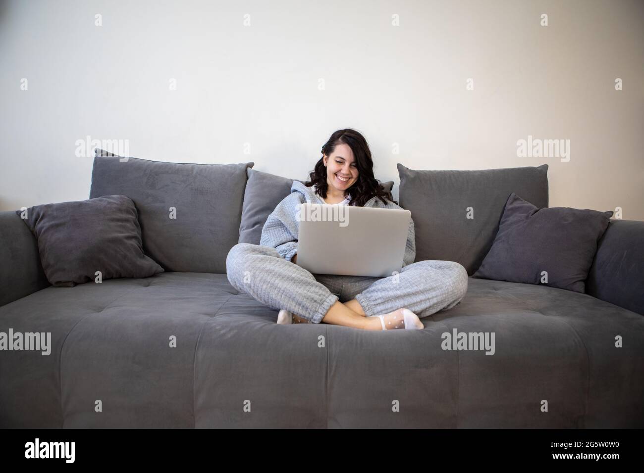 smiling woman sitting on the couch working on laptop copy space Stock ...