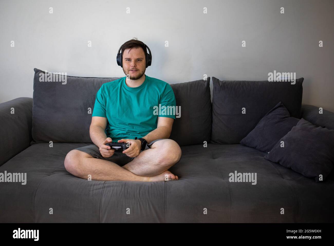 gamer playing video games with controller sitting on couch Stock Photo ...
