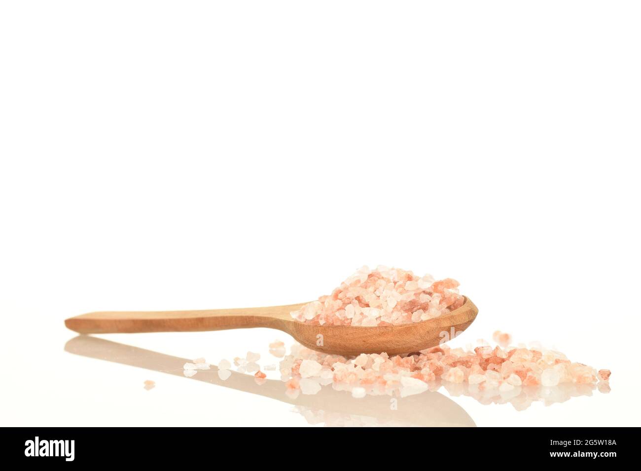 Rock salt of pink color in a wooden spoon, close-up, isolated on white ...