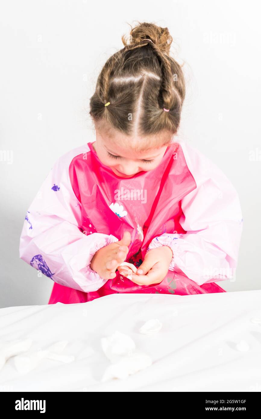 Little girl modeling mermaid tails with white air-dry modeling clay ...