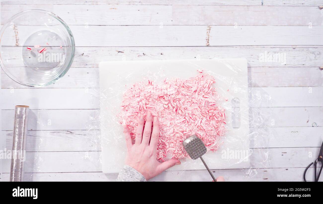 Flat lay. Step by step. Breaking candy cane candies into small pieces ...