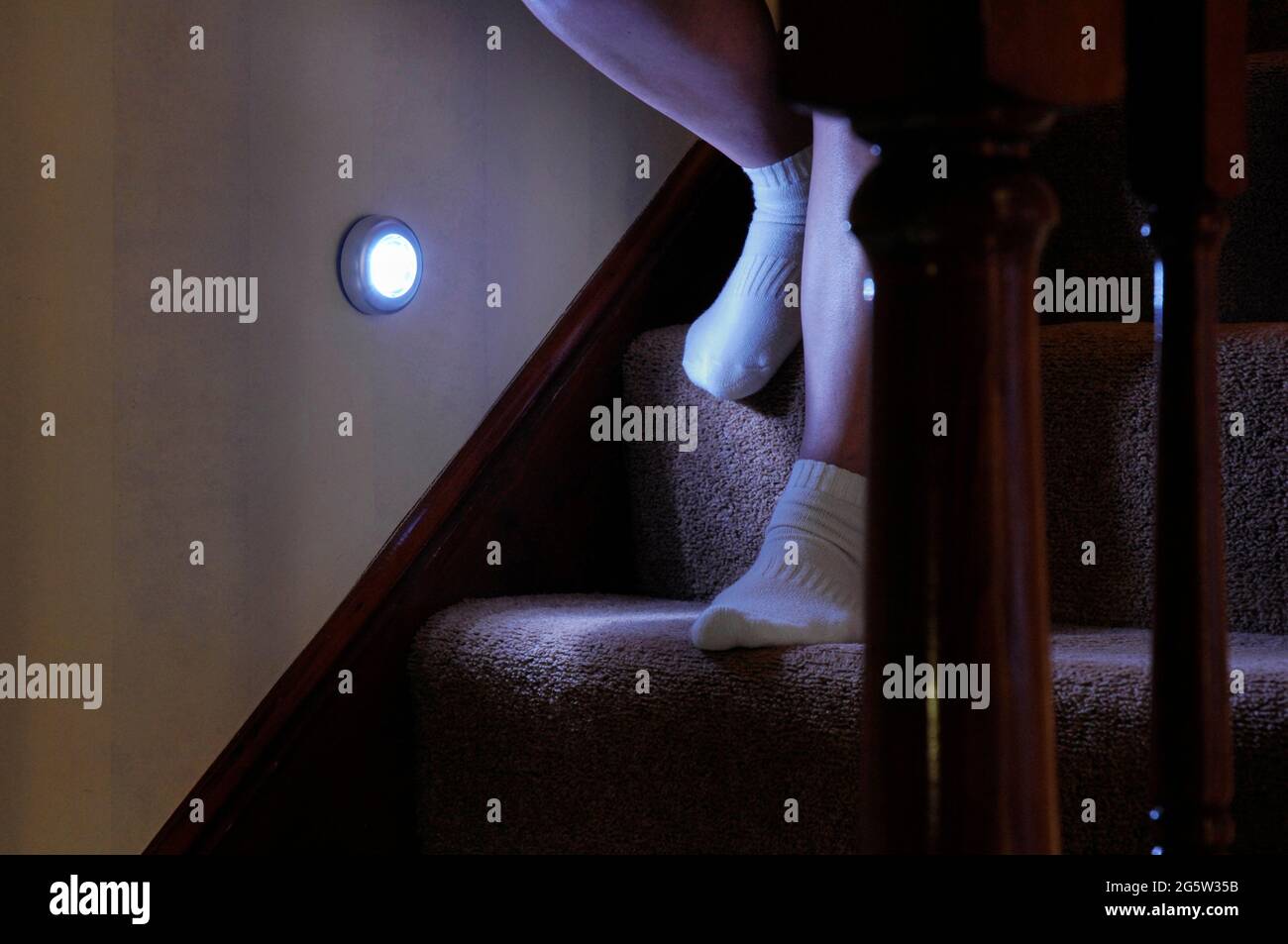 night light on the stairway lighting the way for a person walking down ...