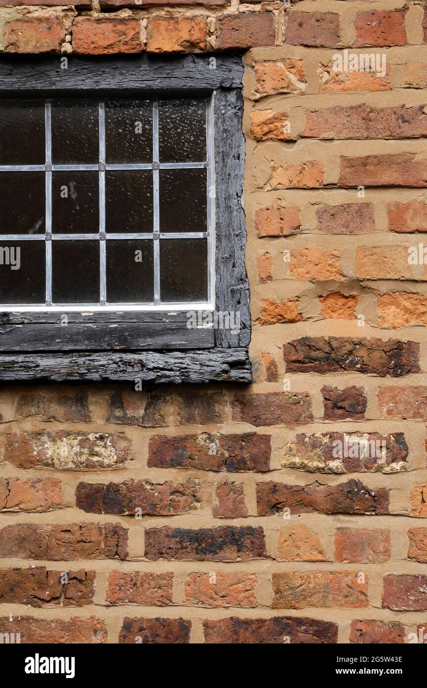 square window with black frame within an old brick wall in the United ...