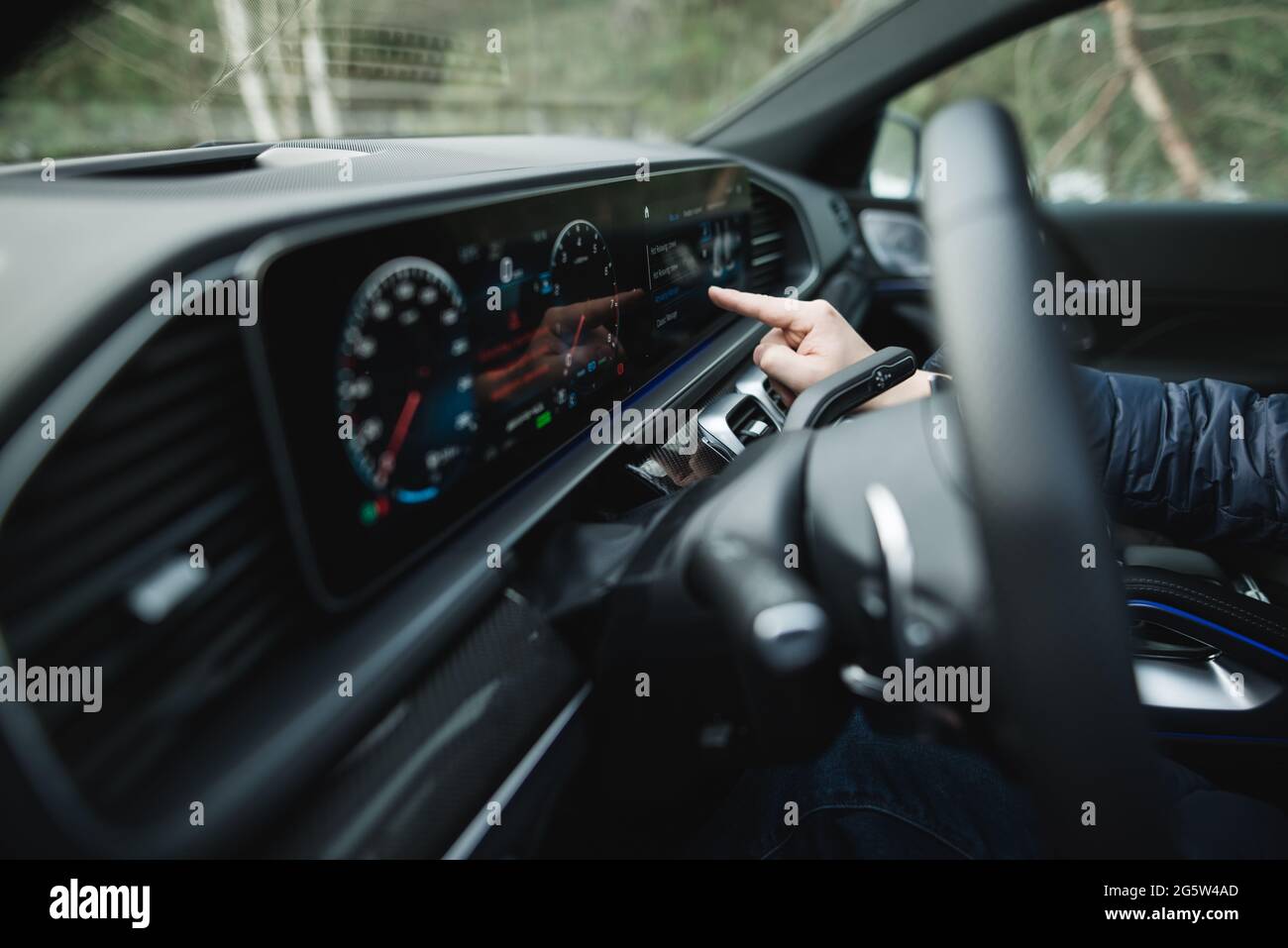 Male driver controls the settings of his car with buttons Stock Photo ...