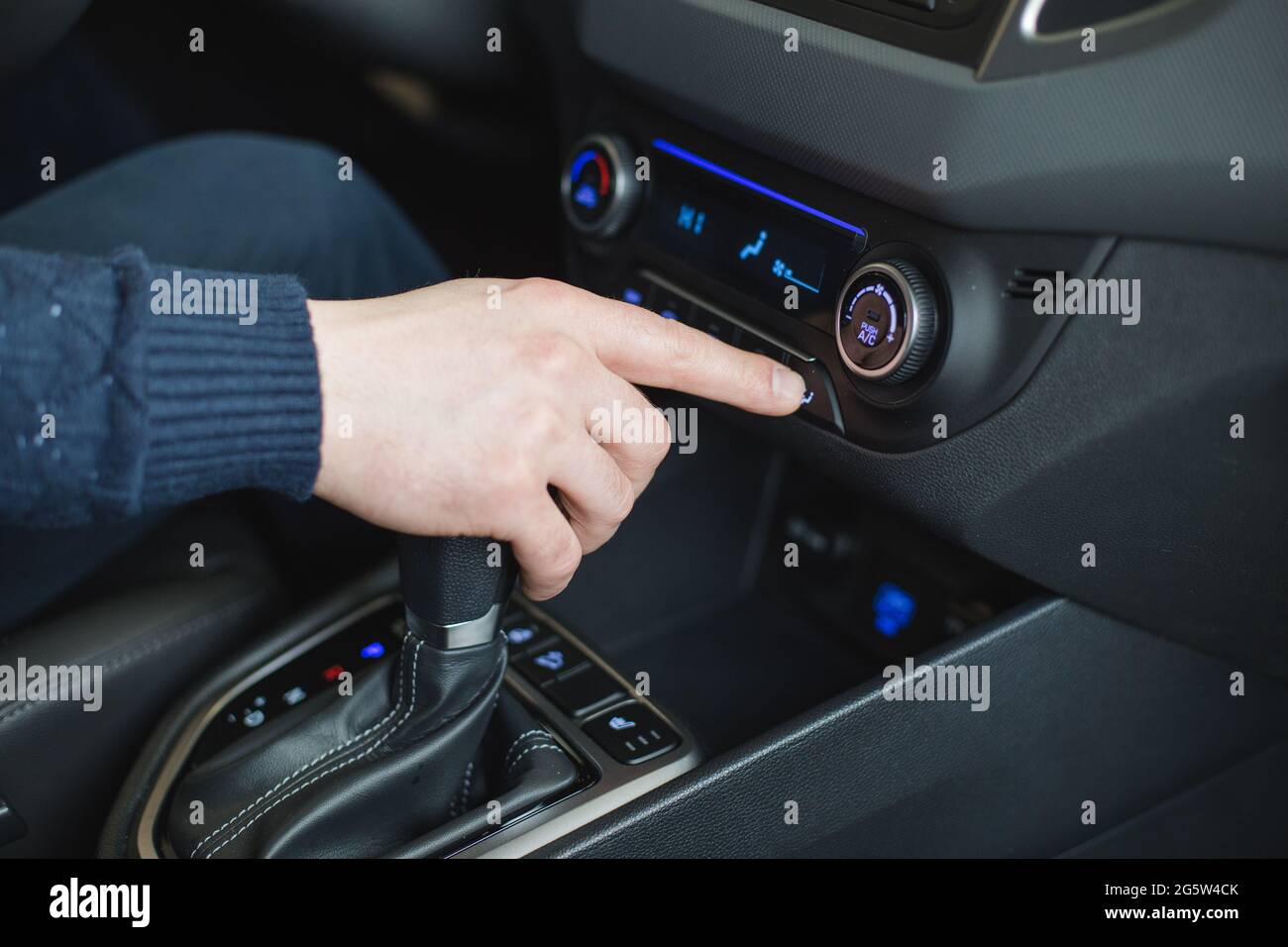 Male driver controls the settings of his car with buttons Stock Photo ...