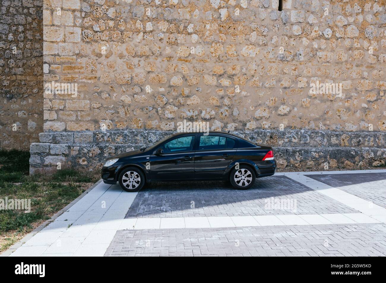 Black car parked next to a 13th century castle wall. Concept of travel ...