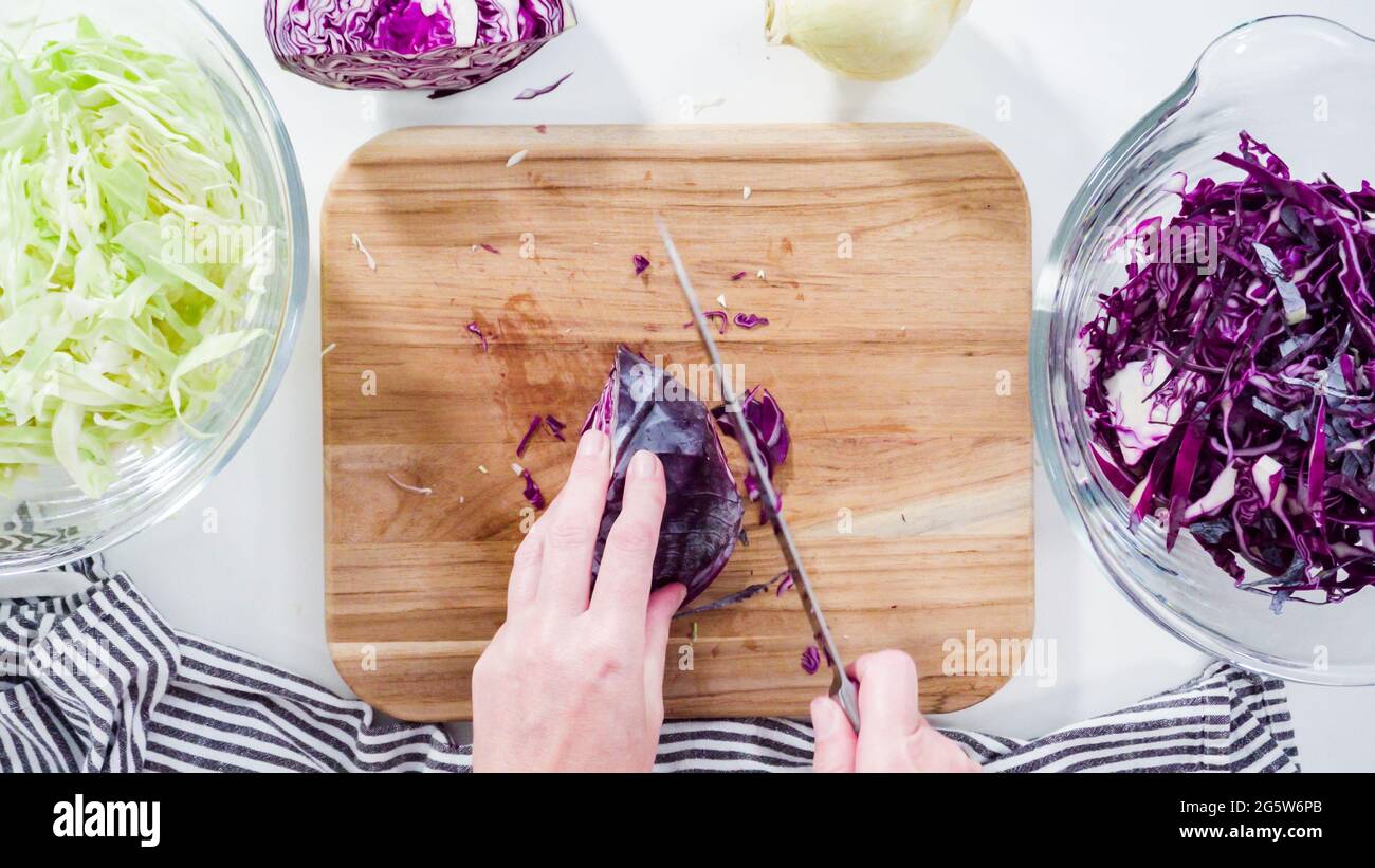 Flat lay. Step by step. Shredding organic cabbage on a wood cutting ...