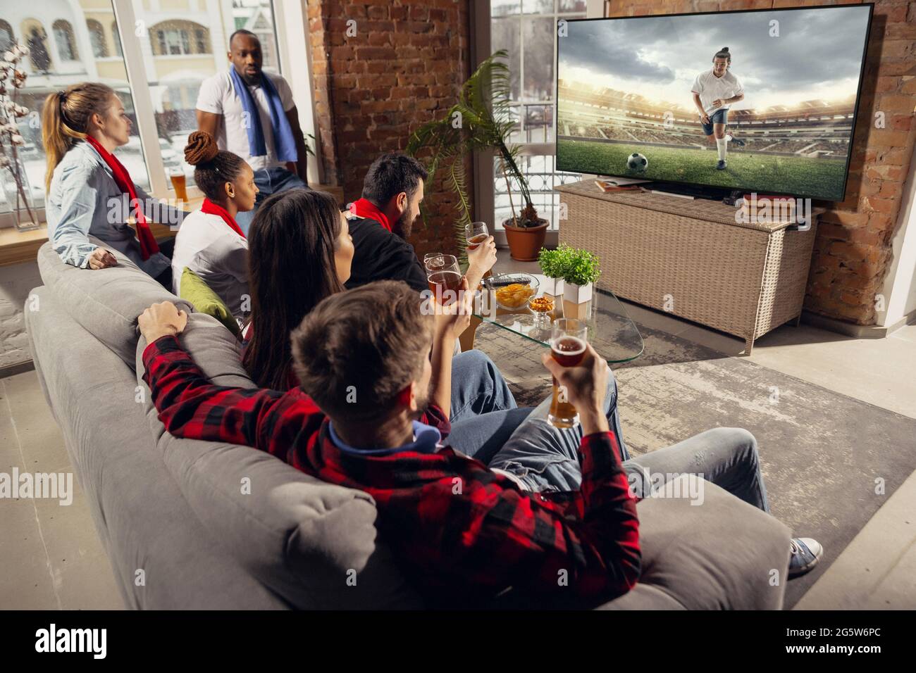 Excited, happy big group of young people watching sport match together ...