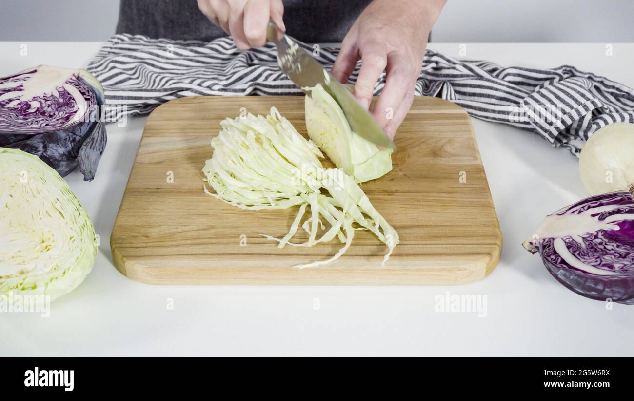 Step by step. Shredding organic cabbage on a wood cutting board Stock ...