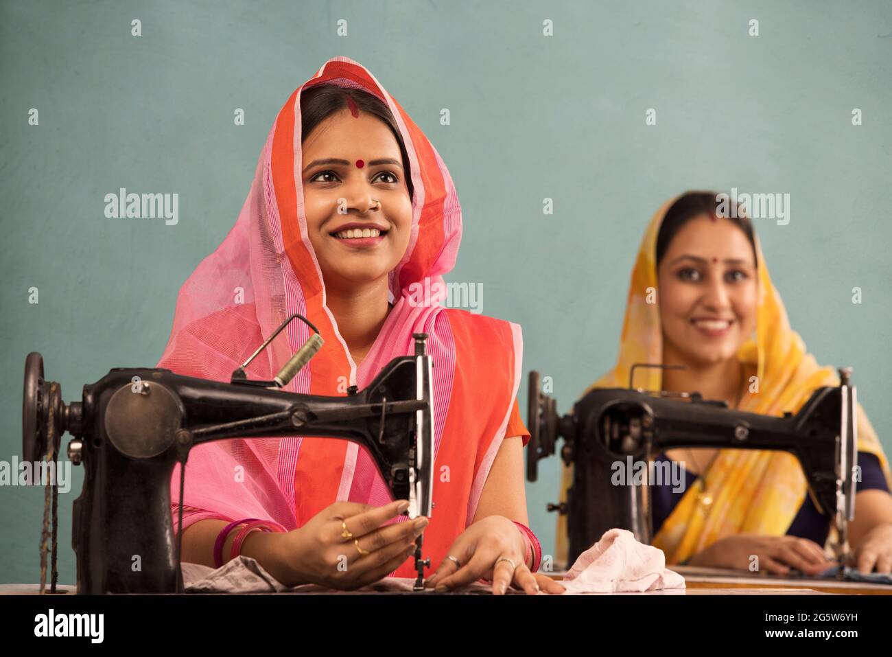 Two rural women working together on sewing machine Stock Photo - Alamy