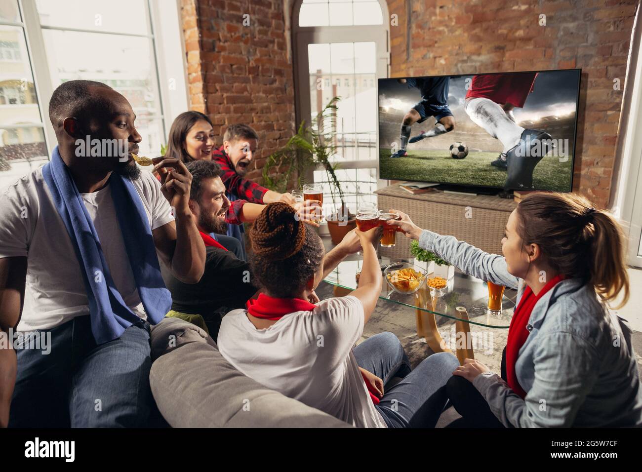 Excited, happy big group of young people watching sport match together ...