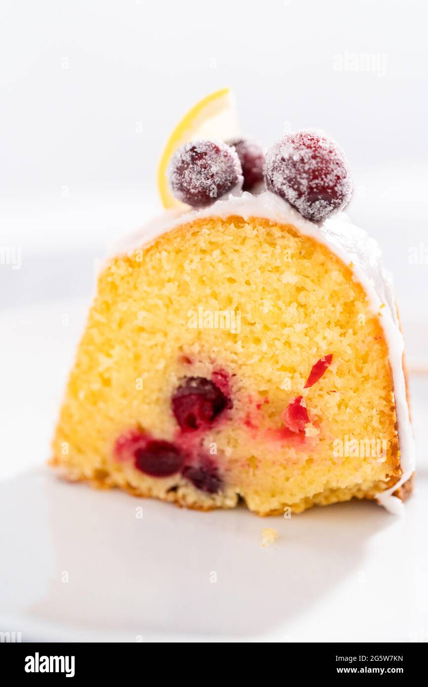 Slice the lemon cranberry bundt cake on a white plate Stock Photo - Alamy