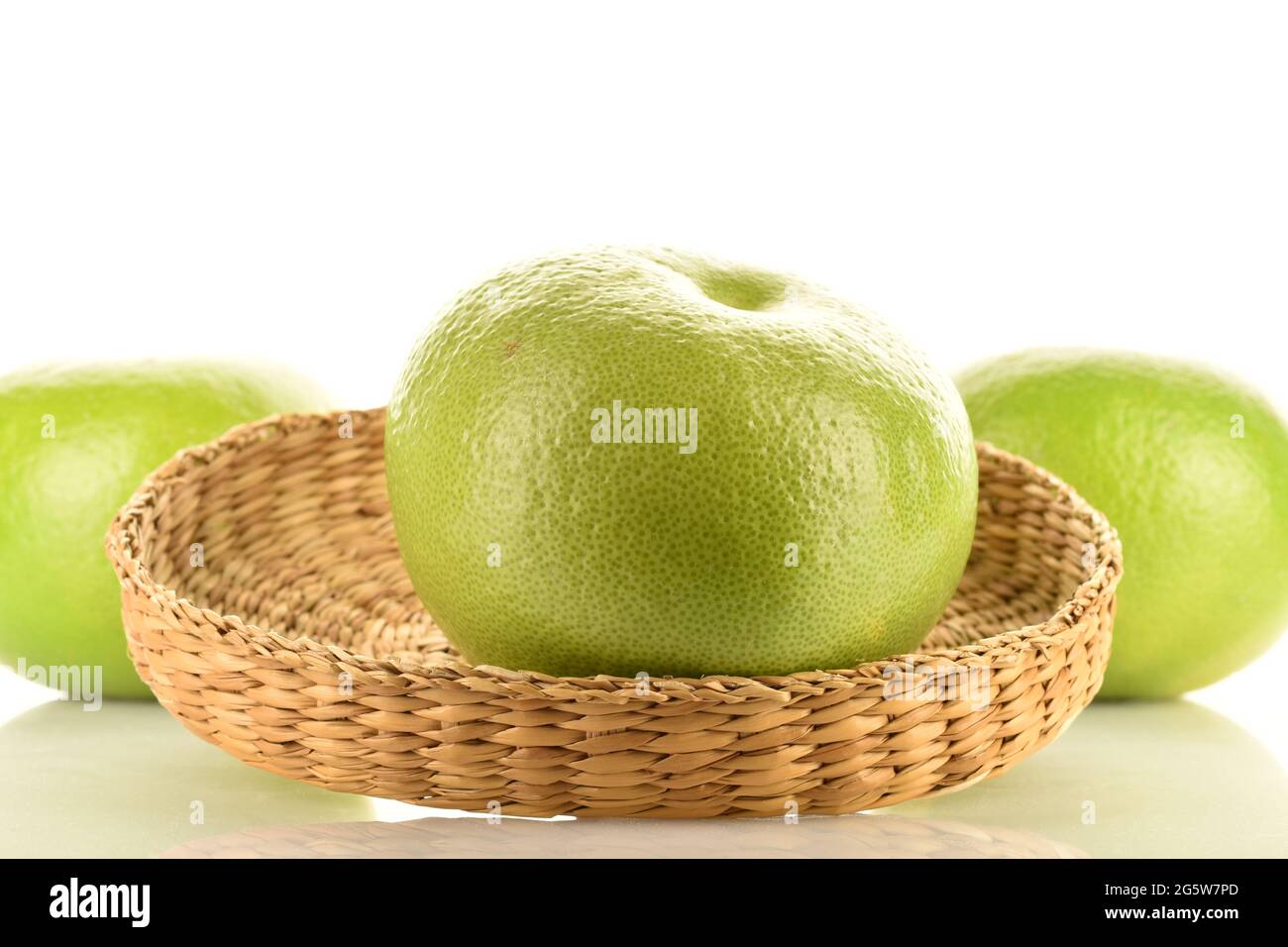 In the foreground is one organic bright green Citrus Sweetie in a straw ...