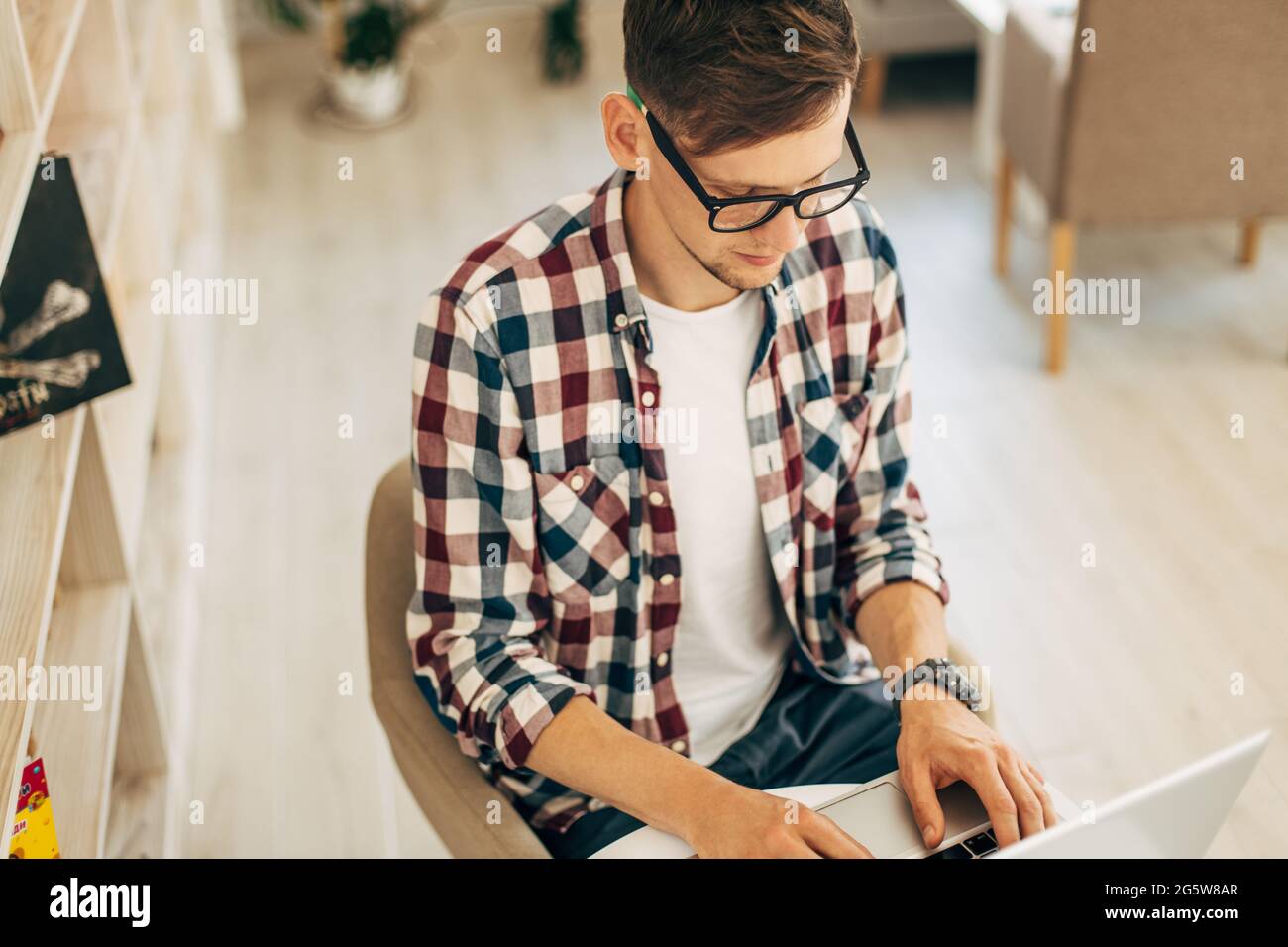 Young man uses laptop works hi-res stock photography and images - Alamy