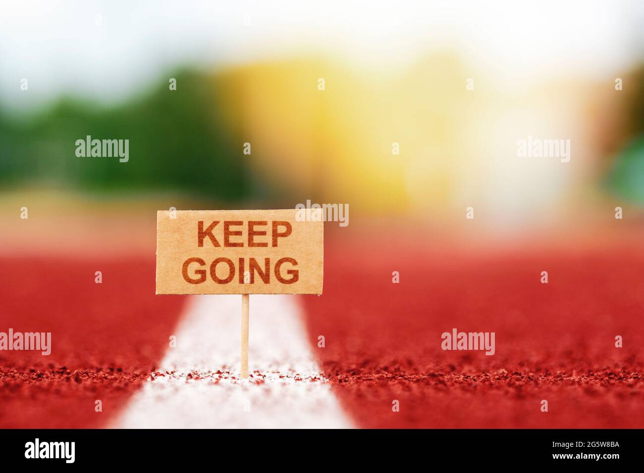 KEEP GOING writing on a text sign on a running track. Motivation ...