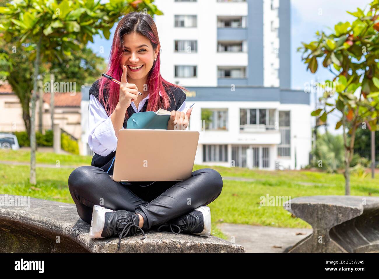 Adult high school student girl pointing up with finger, with laptop and ...