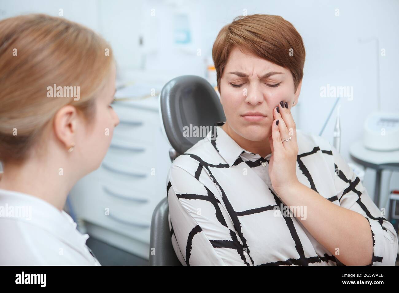 Female patient suffering from toothache, having dental appointment ...