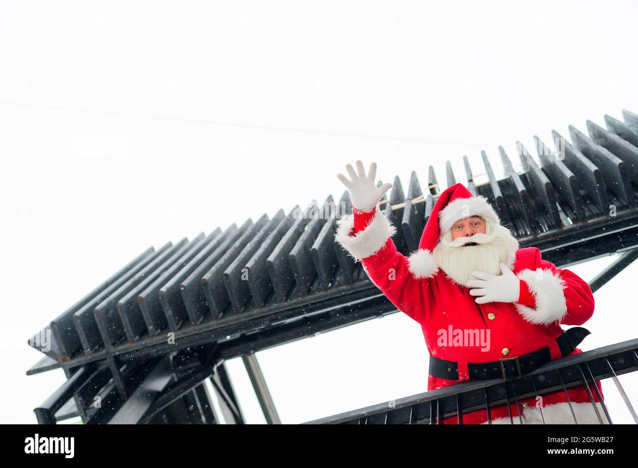 Santa claus looks down from the stairs and wishes a merry christmas ...