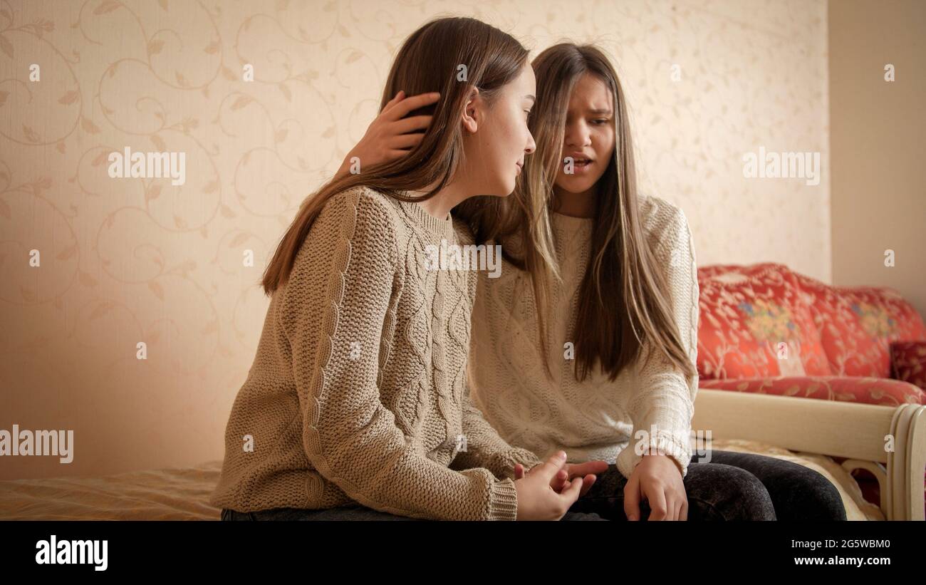 Teenage girl consoling and comforting her friend talking about her ...