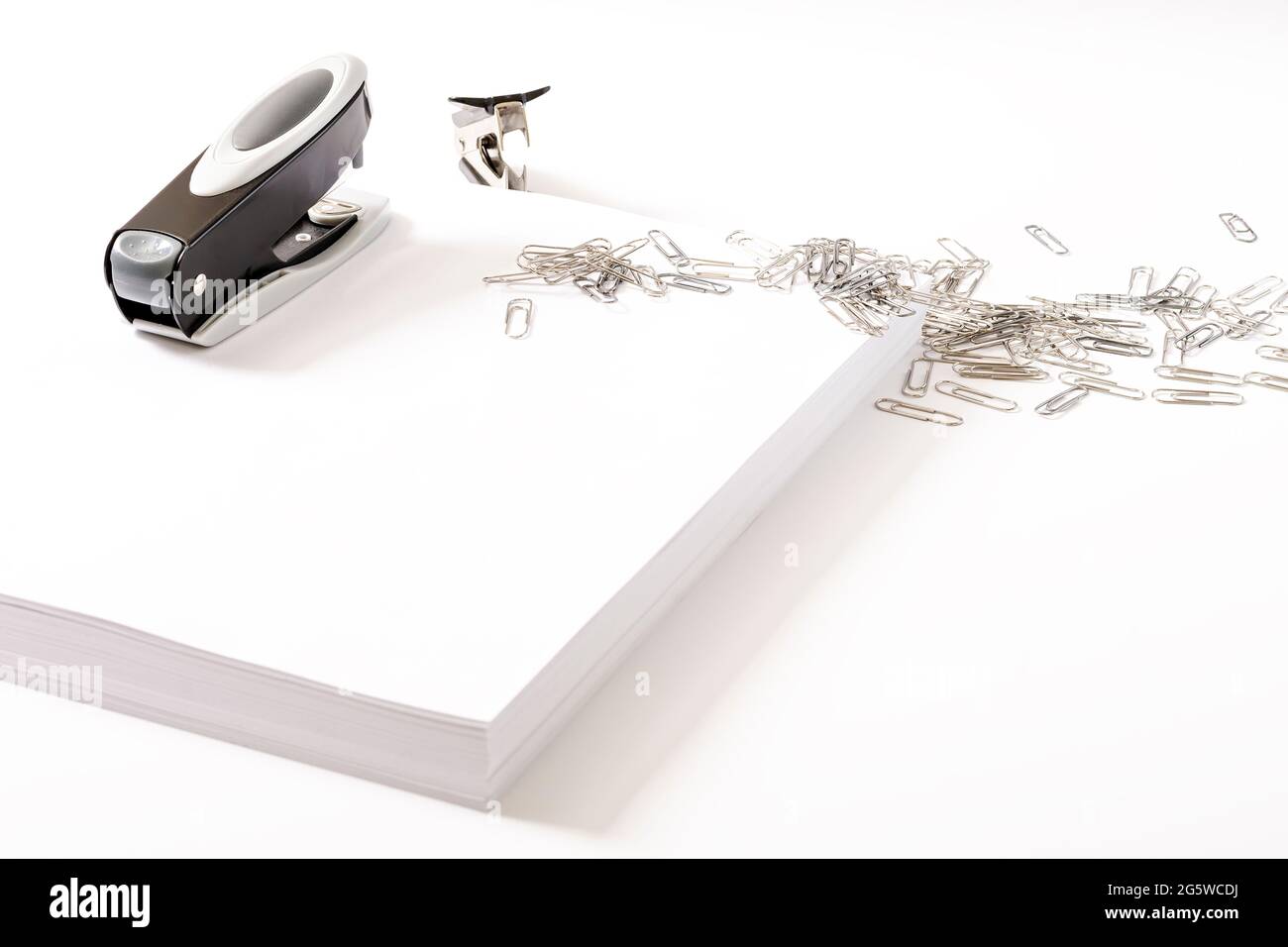 Photograph of some sheets of paper, a stapler, a staple extractor and ...