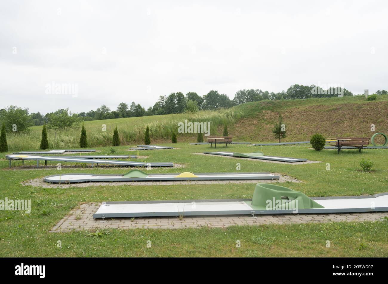 Mini golf court. Summer outdoor game. Green field and trees on ...