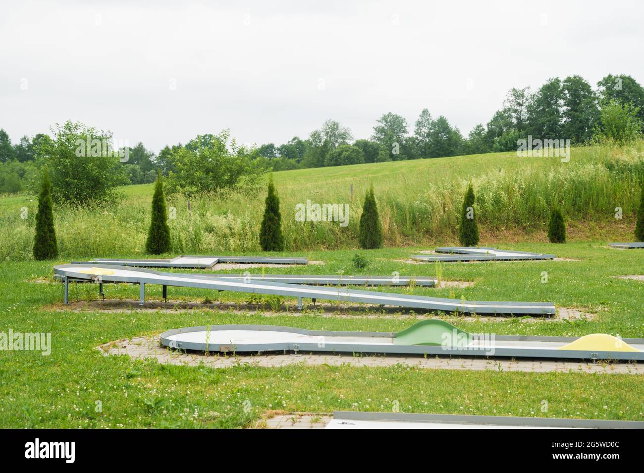 Mini golf course. Summer outdoor game. Green field and trees on ...