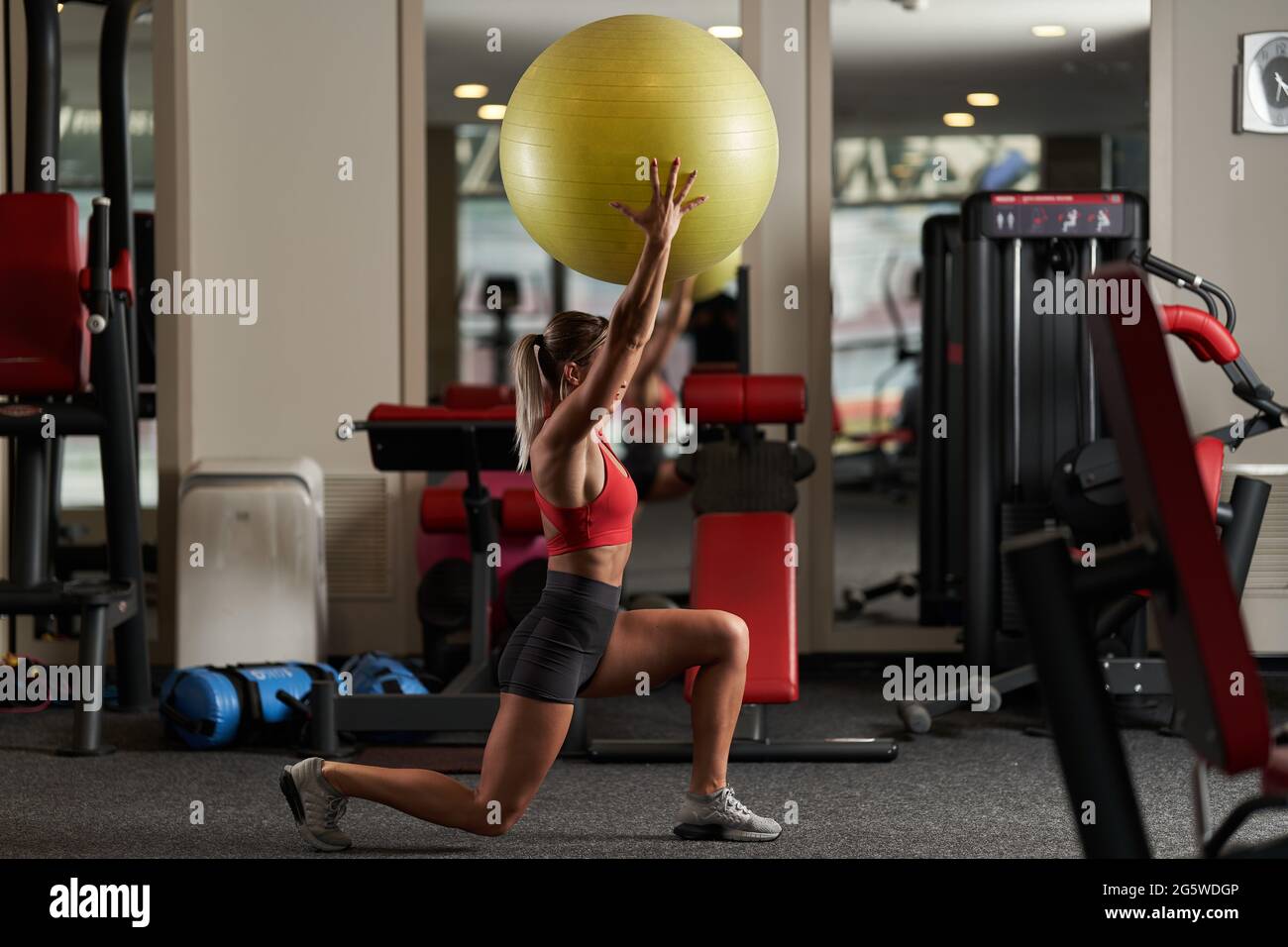 Fitness girl doing lunges with a gym ball Stock Photo - Alamy
