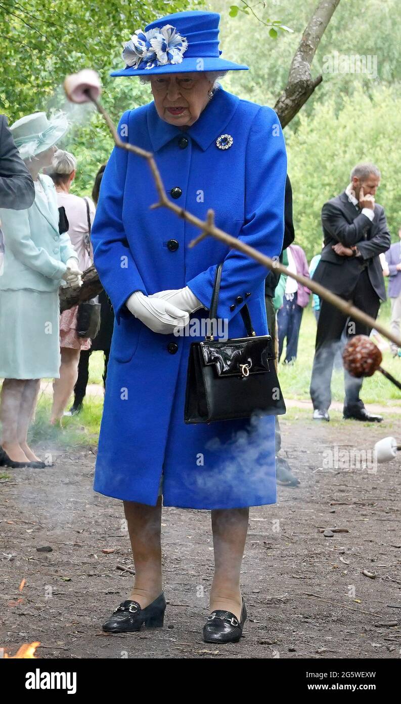 Queen Elizabeth II views marshmallows being toasted during a visit to a ...