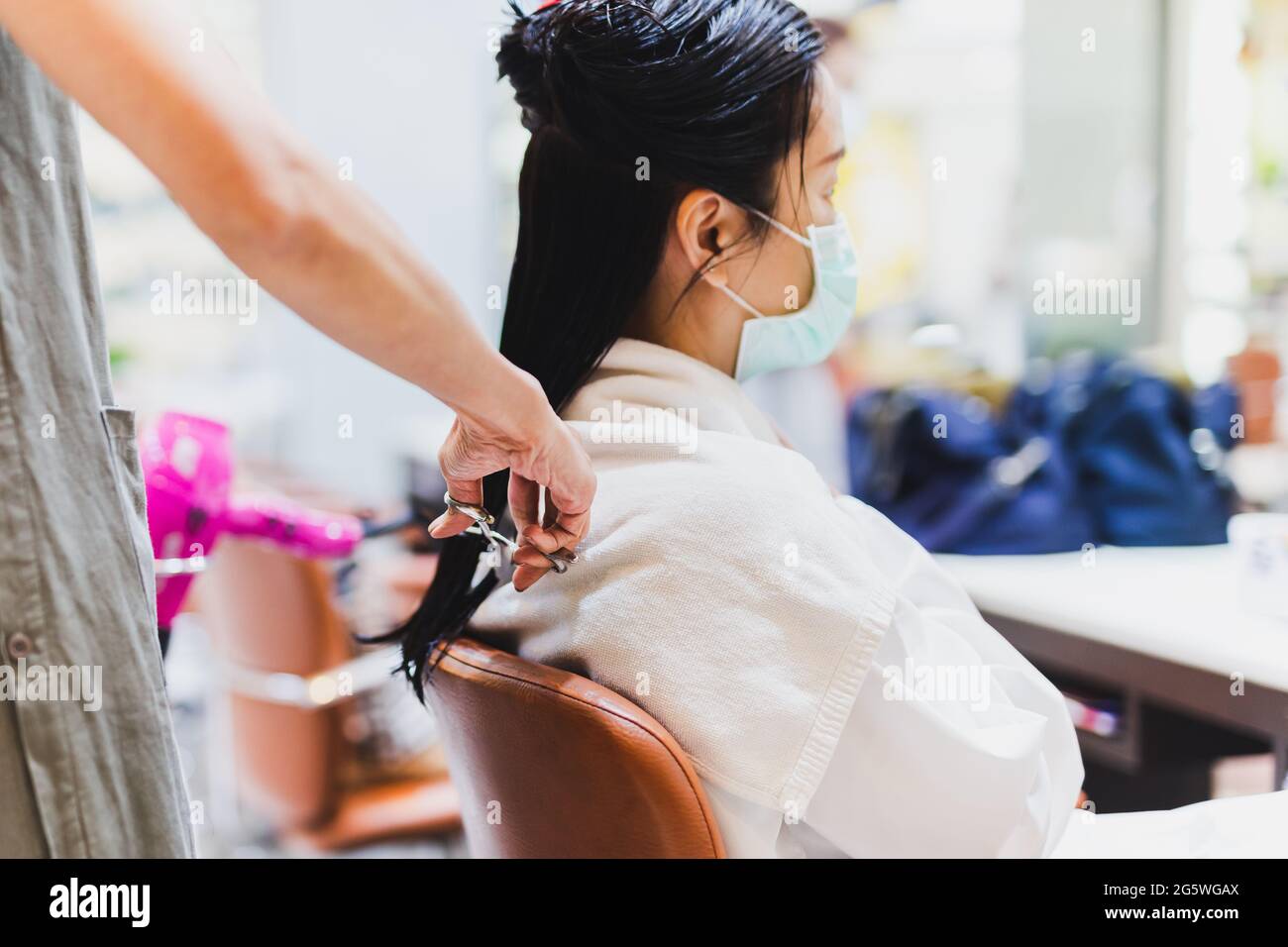 Woman hairdresser with scissors starting to cut client hair Stock Photo ...