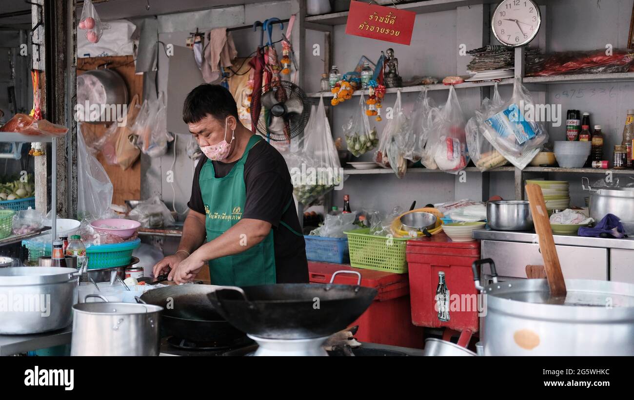 food stall worker wearing a green apron Klong Toey Market Wholesale Wet ...