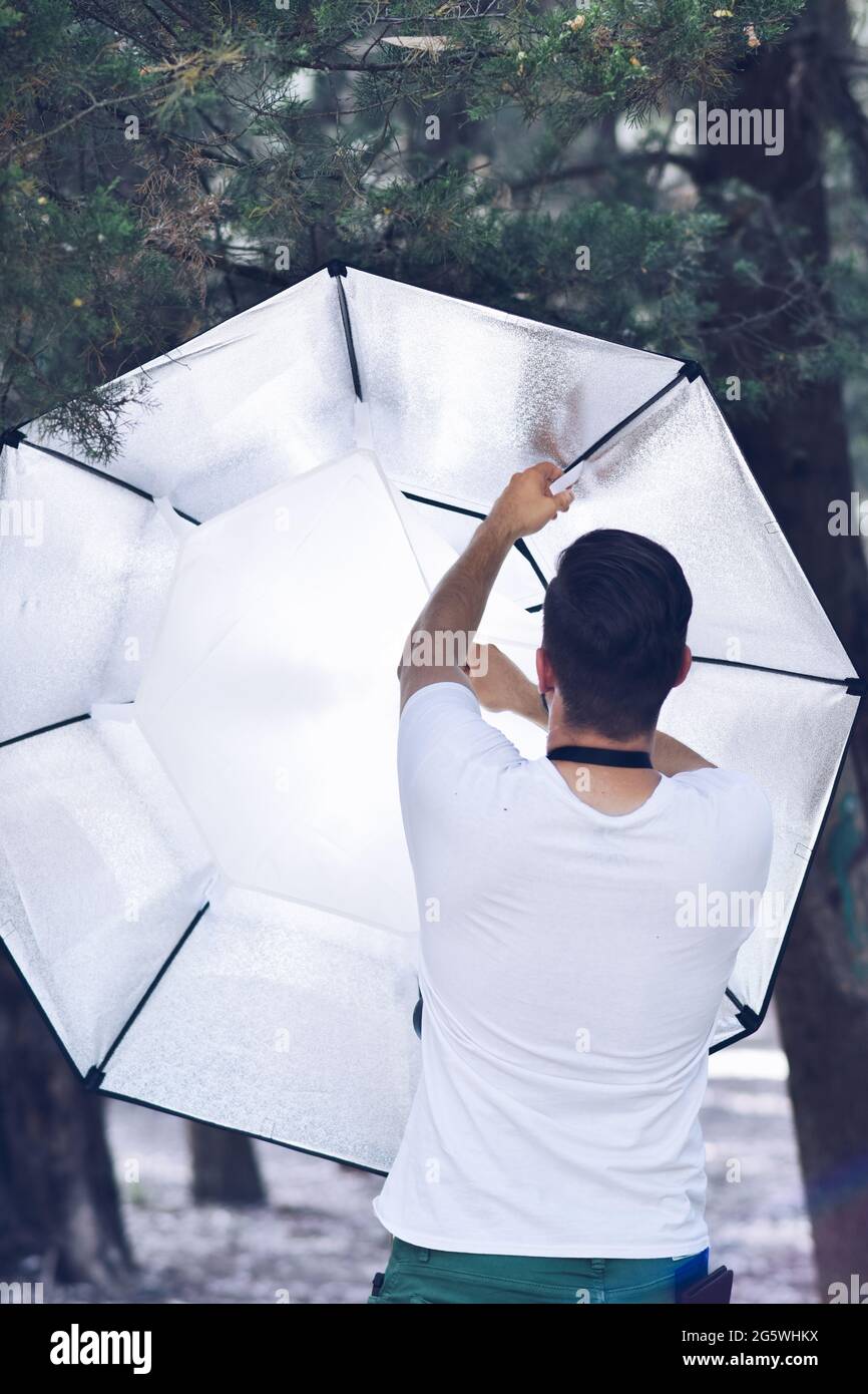 Creative photographer back view adjusting soft box light intesity Stock ...