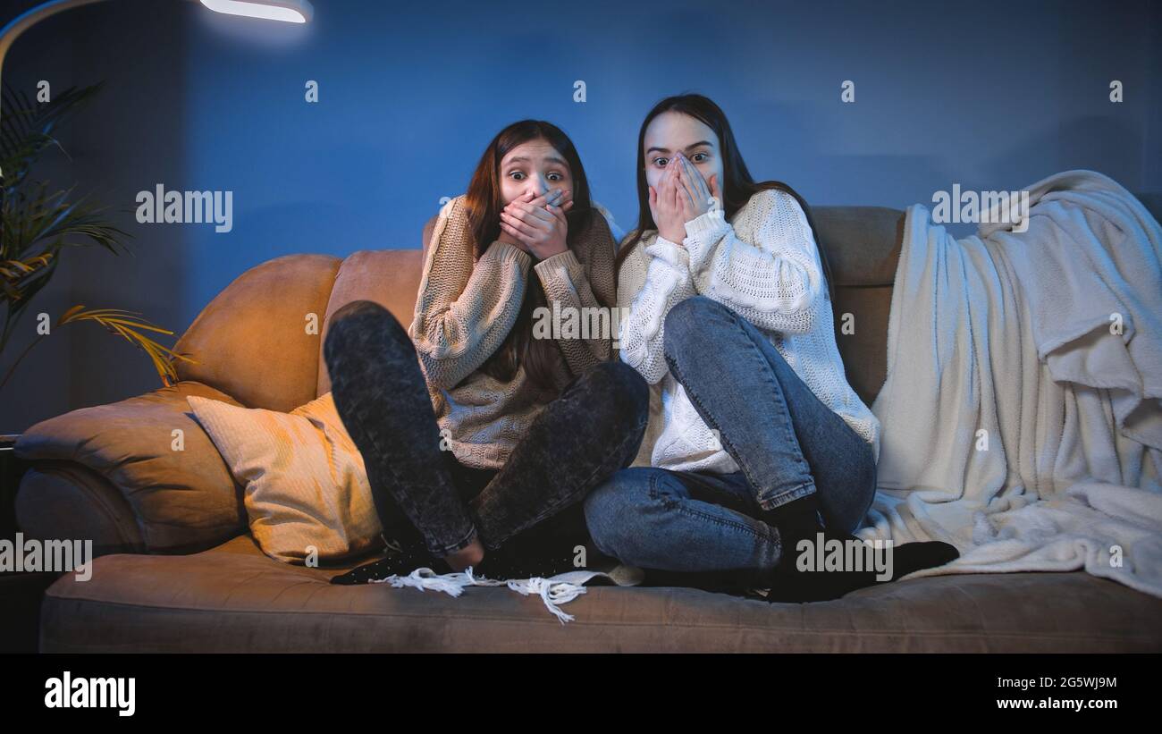 Two girls got scared while watching scary horror movie on TV at night ...