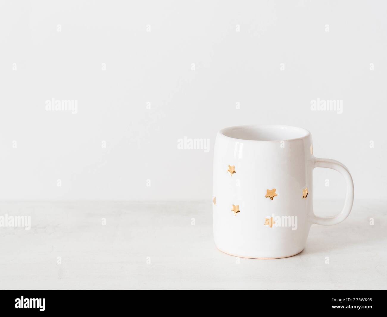 Ceramic cup with gold stars, minimal Christmas decoration and on white ...