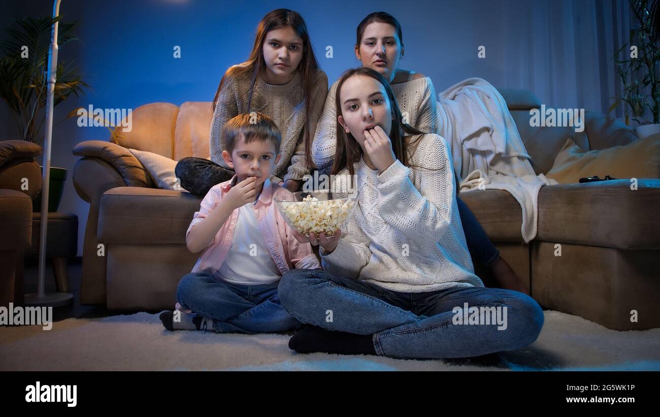 Group of people eating popcorn while watching movie or TV show in ...