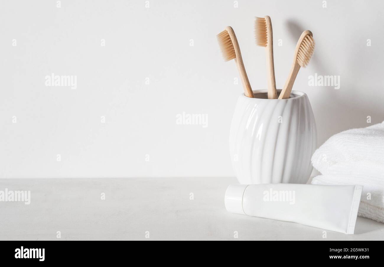 Minimal bath background with bamboo toothbrushs in ceramic glass, white ...