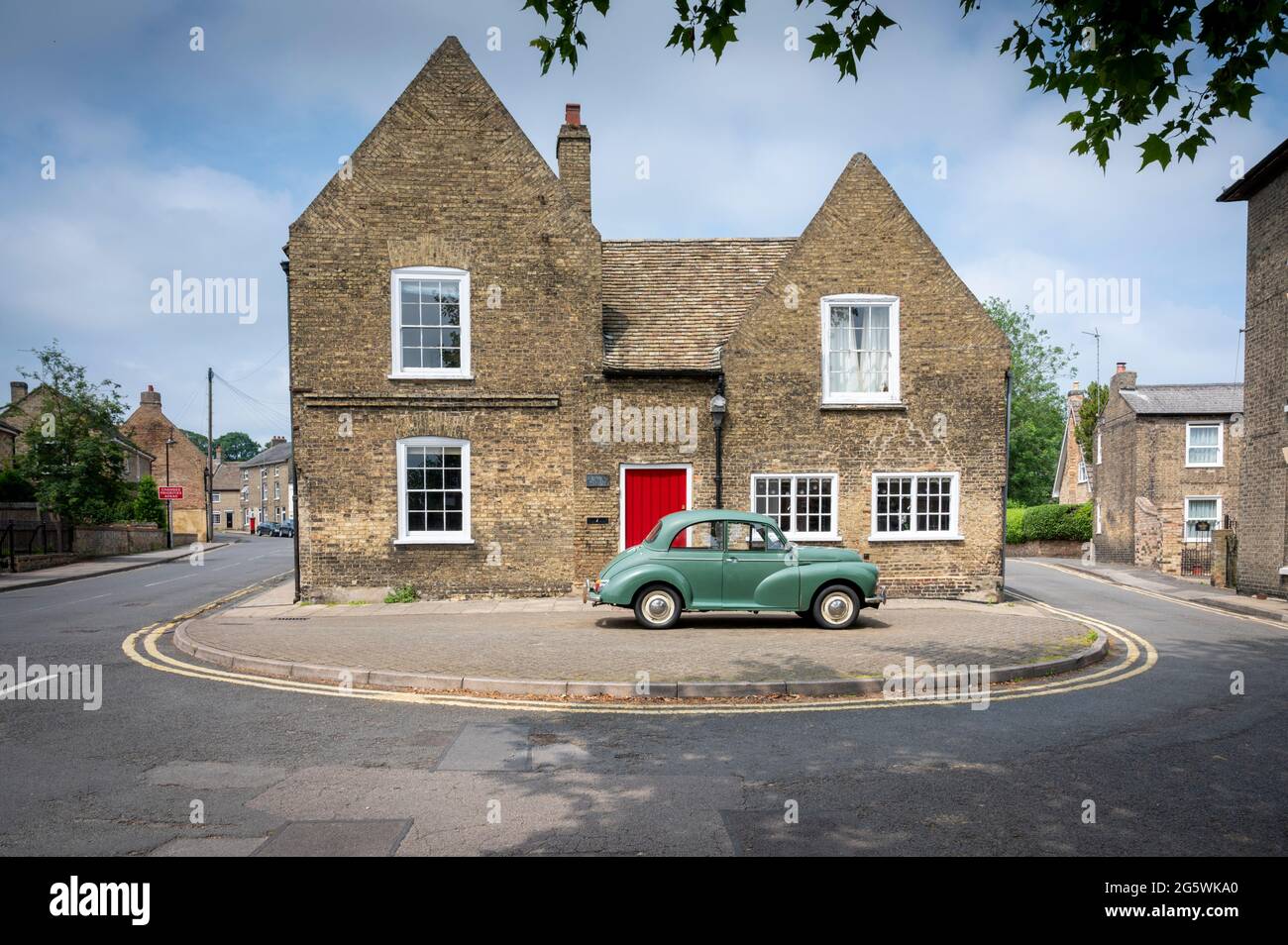 An old Morris Minor vintage car parked on the pavement outside an old ...
