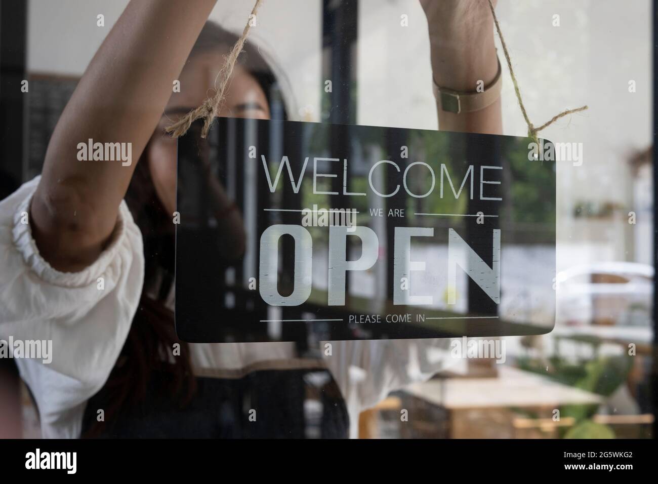 Women hanging open sign hi-res stock photography and images - Alamy