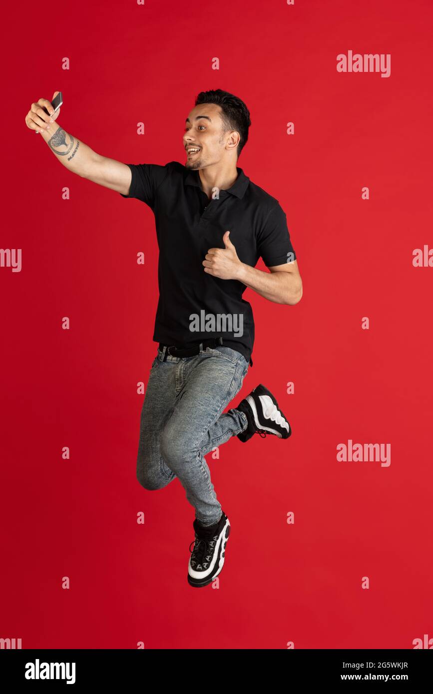 Happy man jumping and taking selfie. Dynamic image of Caucasian male ...