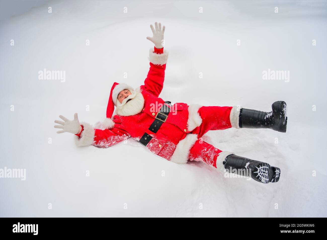 Happy santa claus lying in the snow and fooling around Stock Photo - Alamy