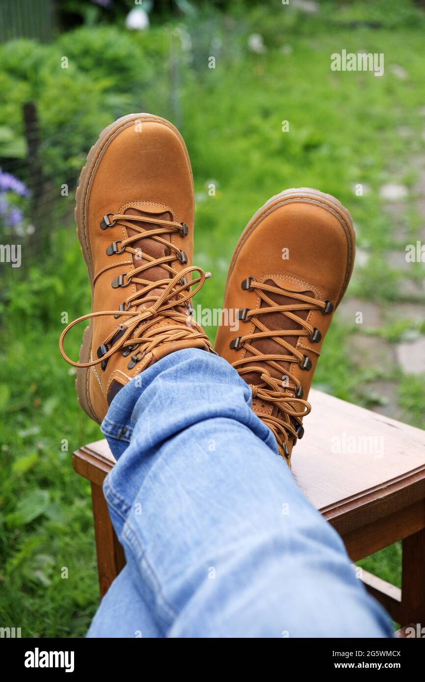 Brown boots and jeans on the legs. Legs are crossed on the stool Stock ...