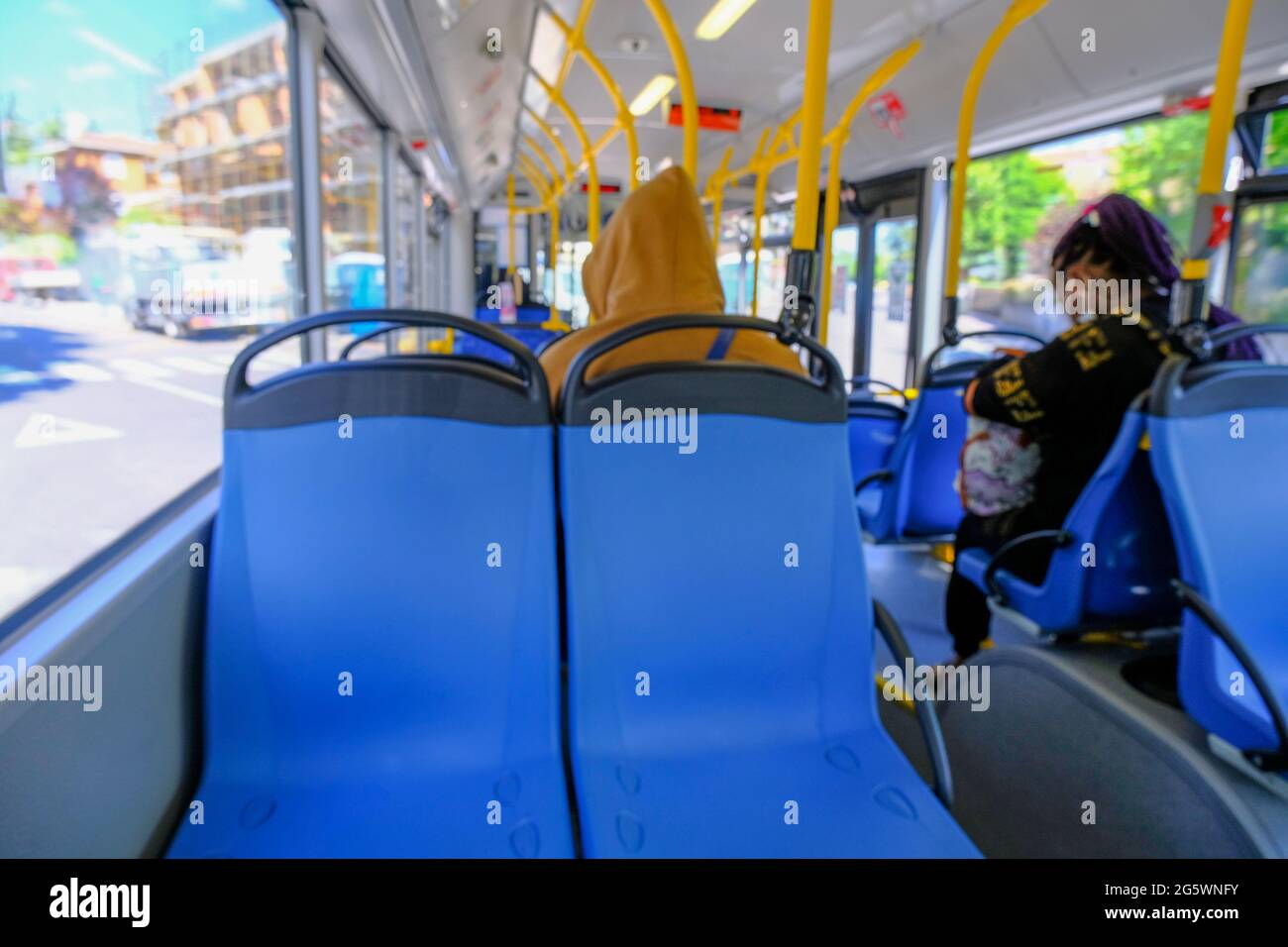 Black table with orange chairs across plants, colorful buildings in a ...