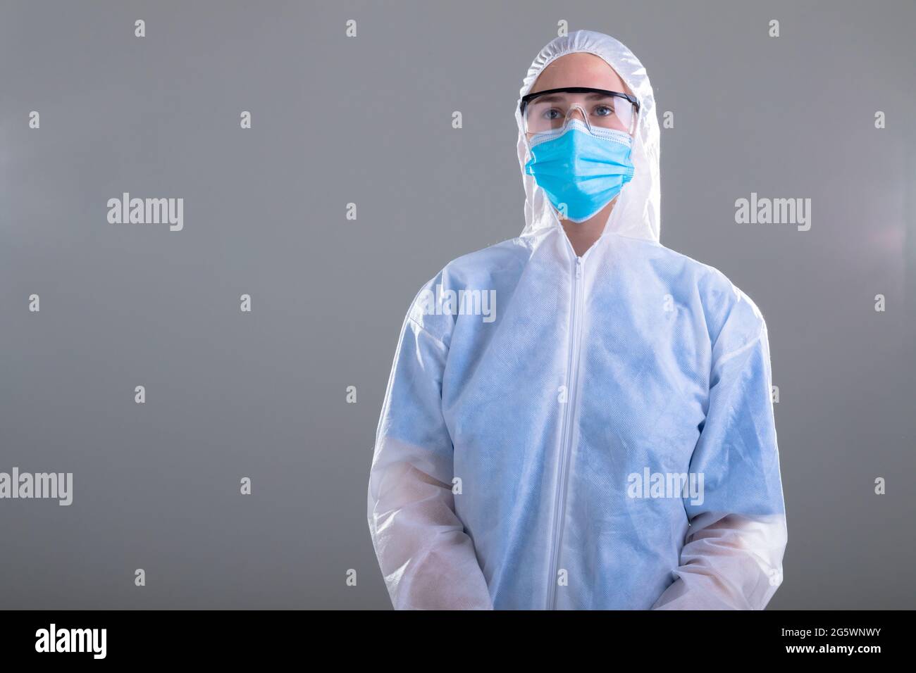 Caucasian female doctor wearing ppe suit, isolated on grey background ...