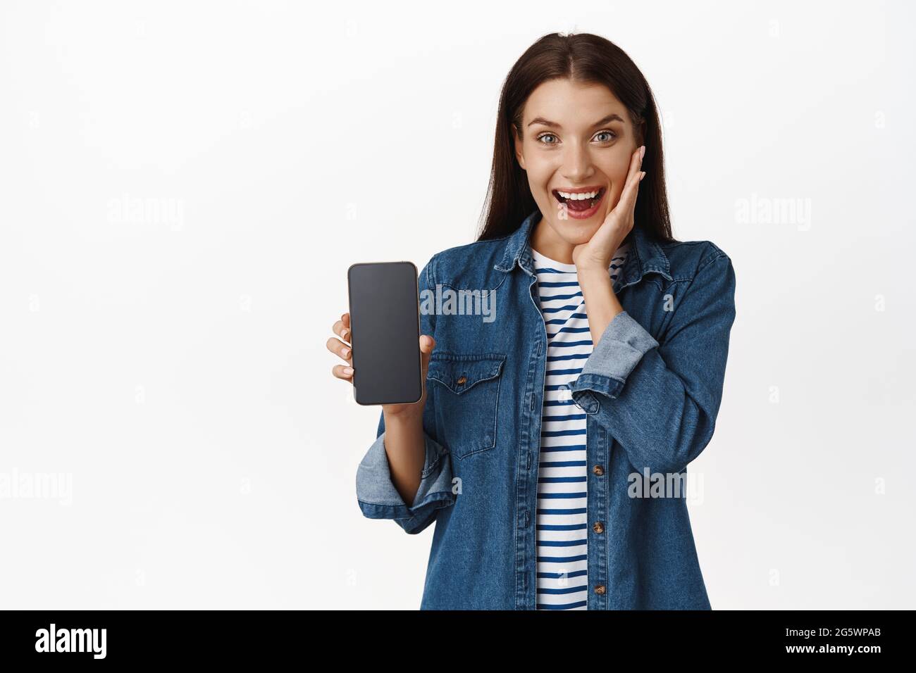 Surprised and happy woman showing smartphone empty screen, phone ...
