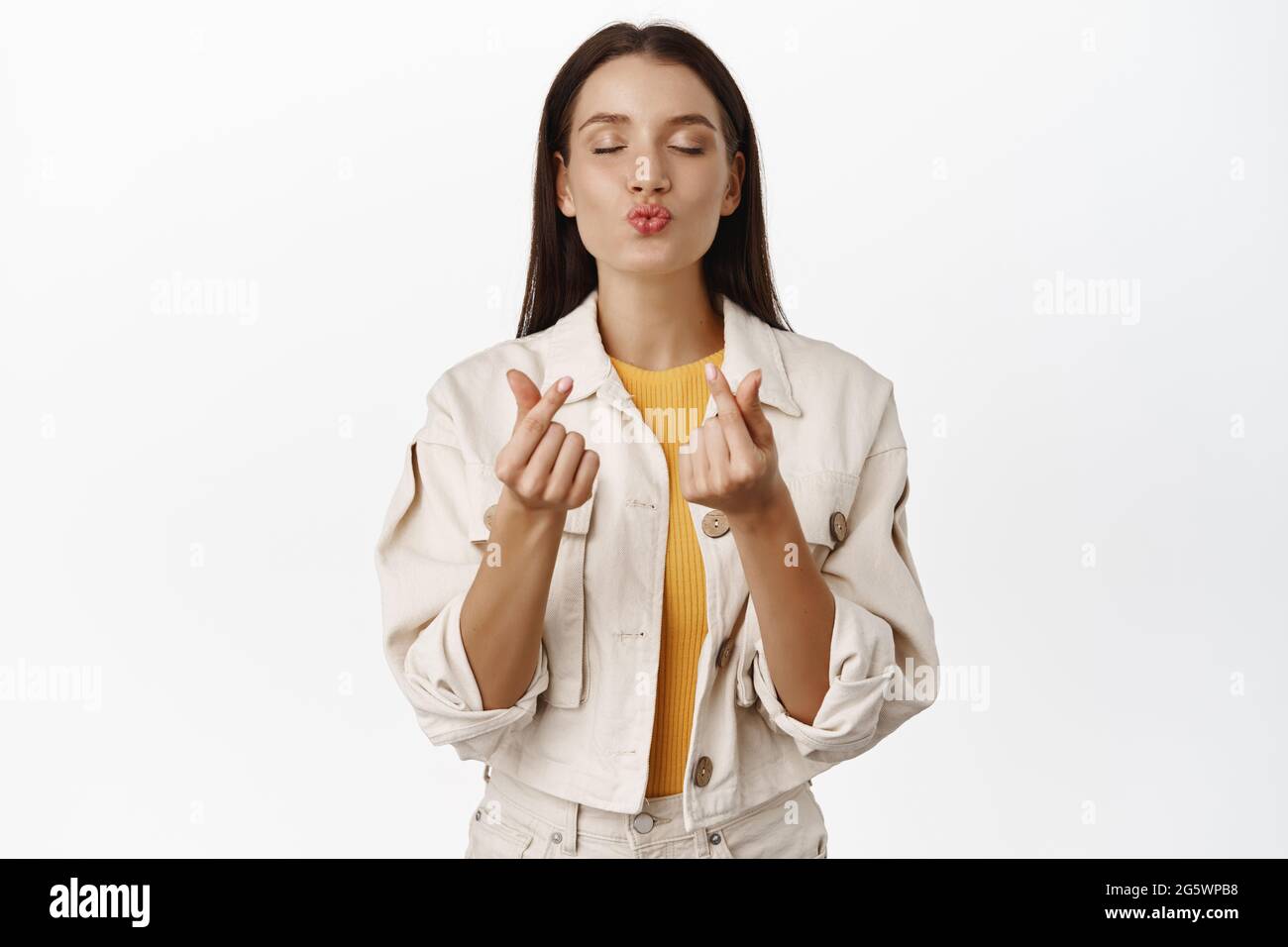 Feminine cute girl close eyes, kissing lips and finger hearts gesture ...