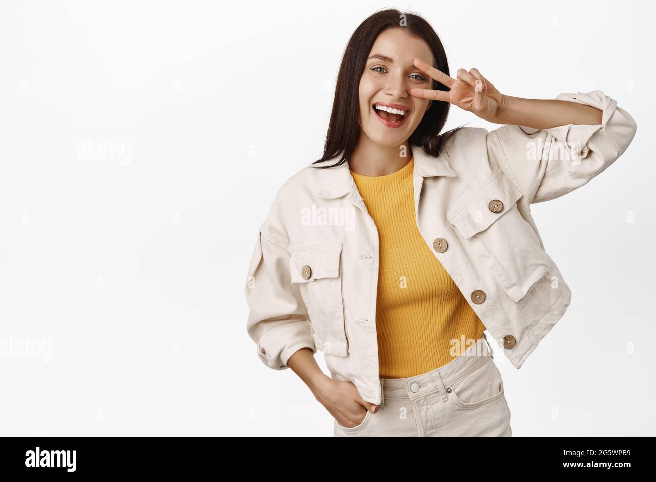 Positive adult woman laughing, smiling happy and showing peace v-sign ...