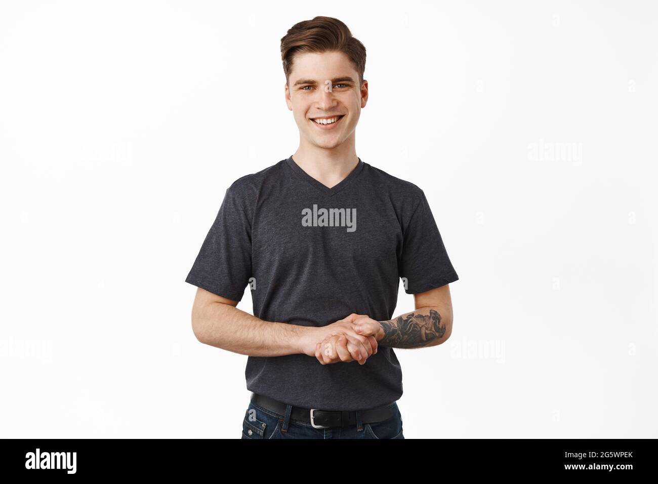 Happy to assist you. Smiling helpful young man holding hands together ...