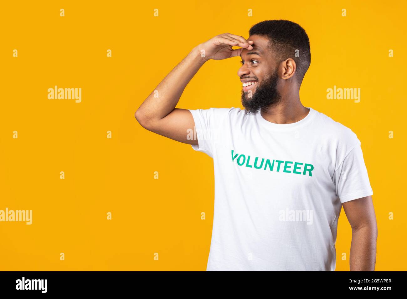 African Volunteer Guy Looking Aside At Copy Space, Yellow Background ...