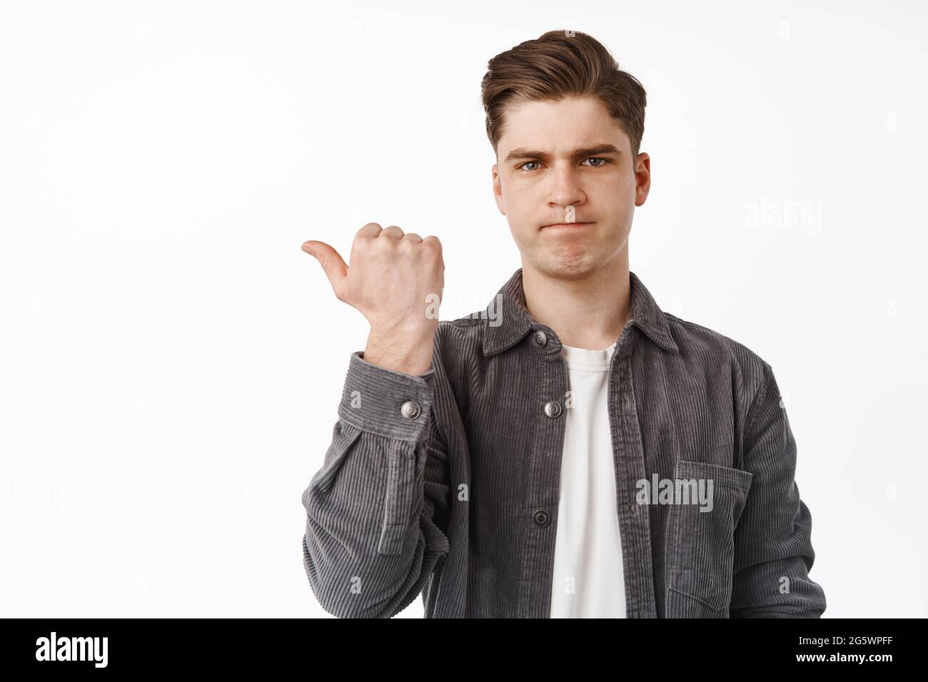 Angry and displeased young man, guy pointing left and look skeptical ...