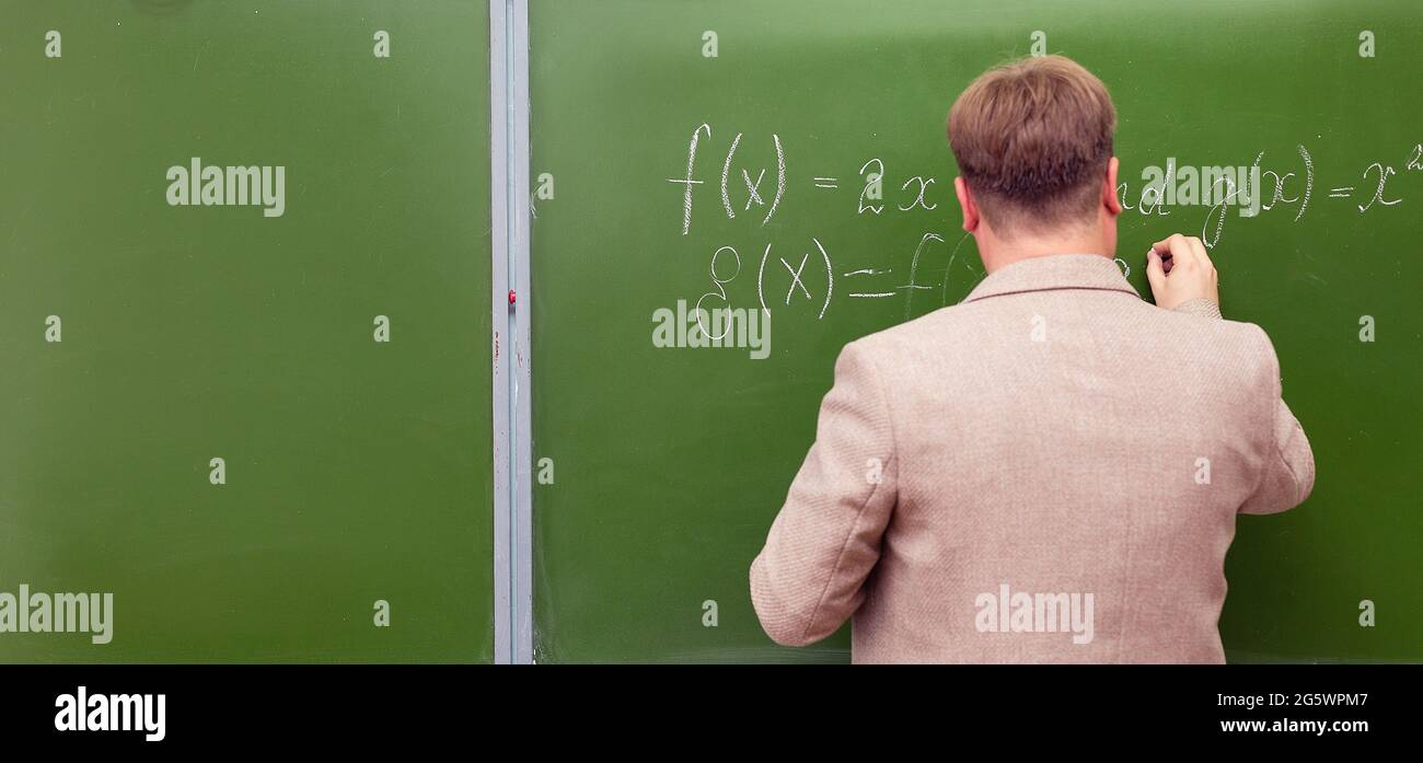 A math teacher shows students the solution of a problem at the school ...
