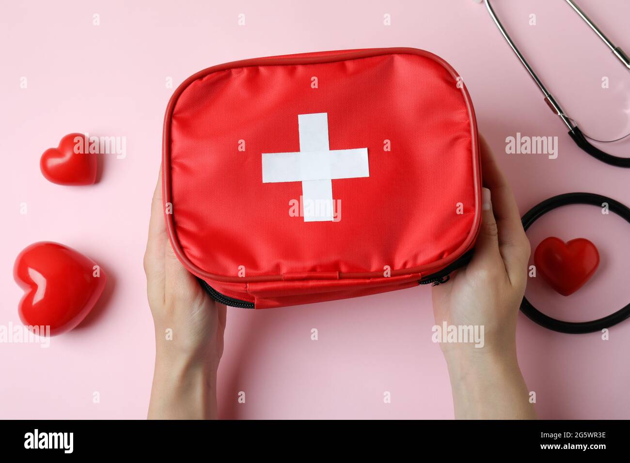 Female hands hold first aid medical kit on pink background Stock Photo ...